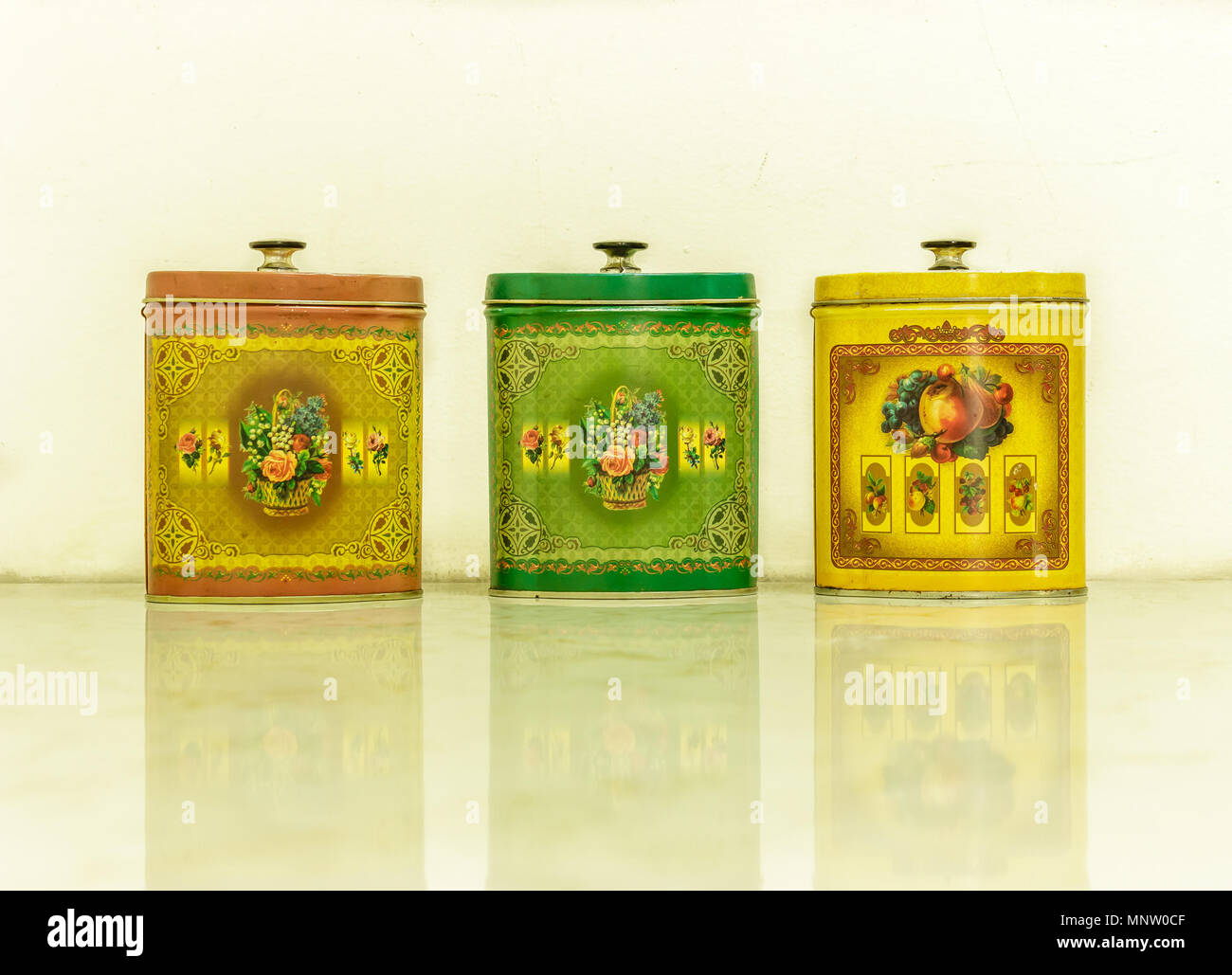 Three oval vintage colorful tin storage with cover on white background ...