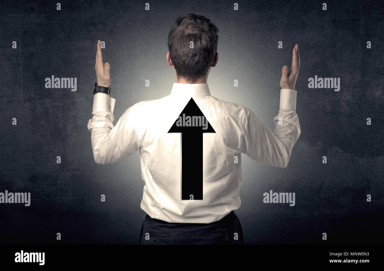 Young businessman standing and thinking about which direction to choose ...