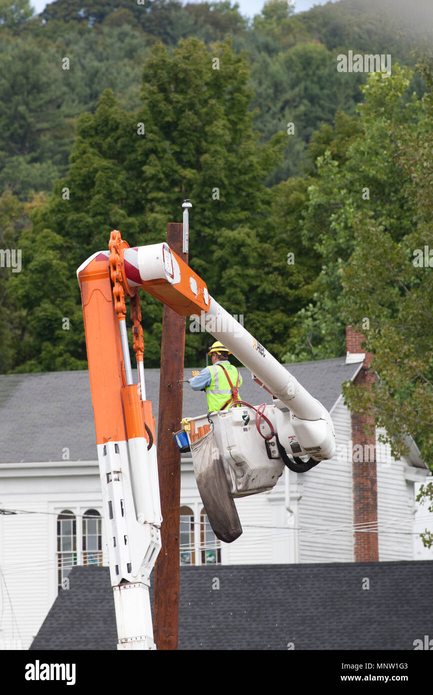 Line man using bucket lift installing upgraded electrical service along ...