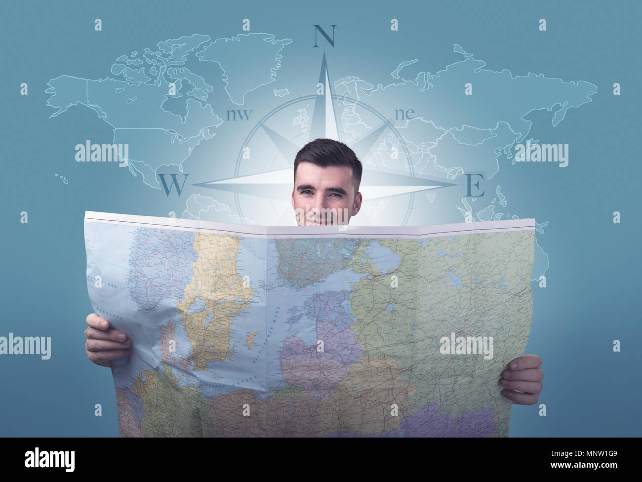 Handsome young man holding a map with a world map and a compass behind ...