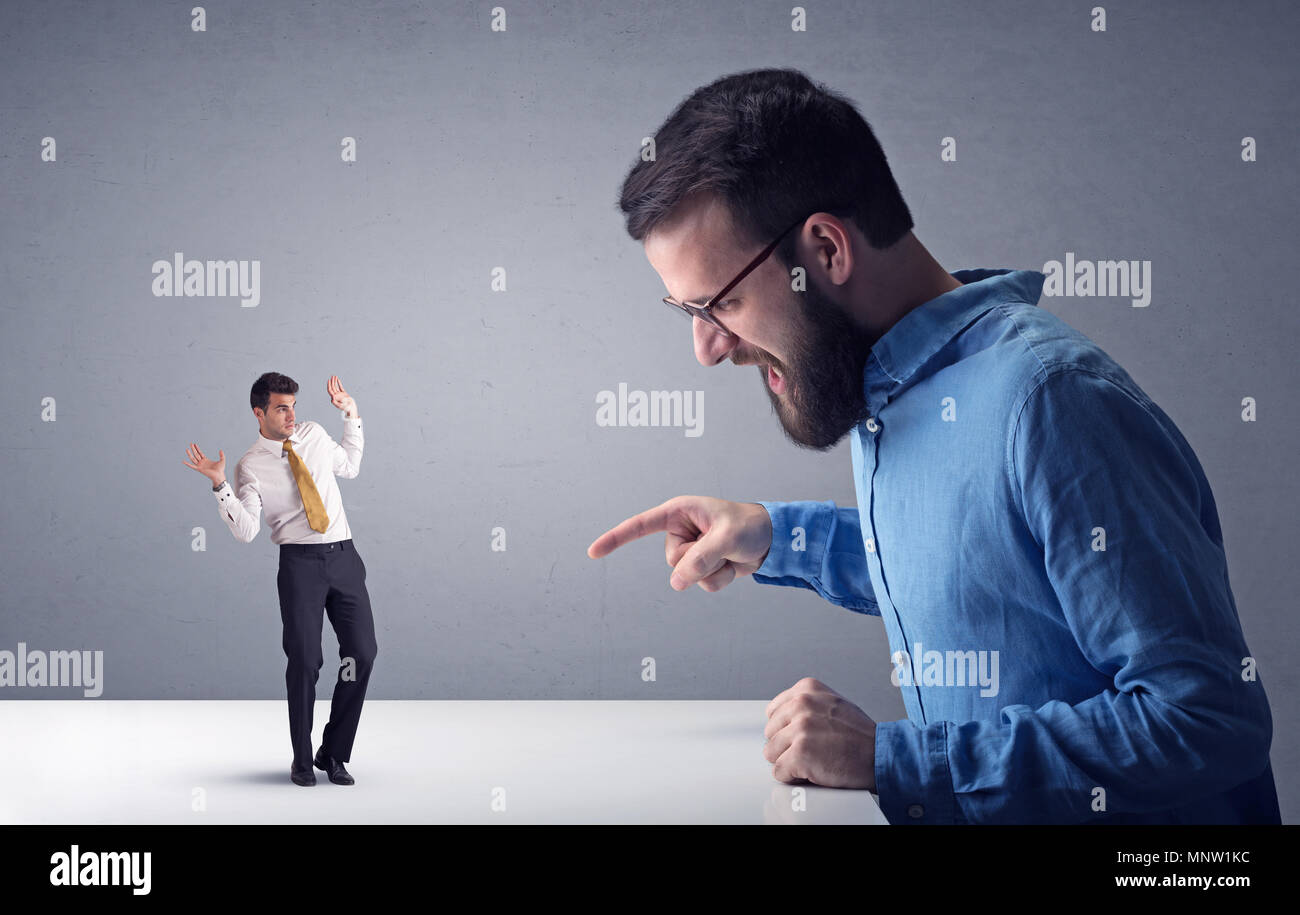 Young professional businessman being angry with an other miniature ...