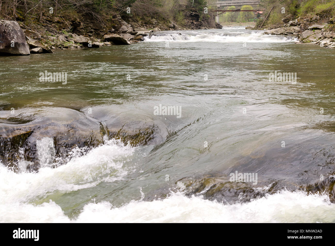 Strong flow and boiling of water in mountain river with splashes. Fast ...