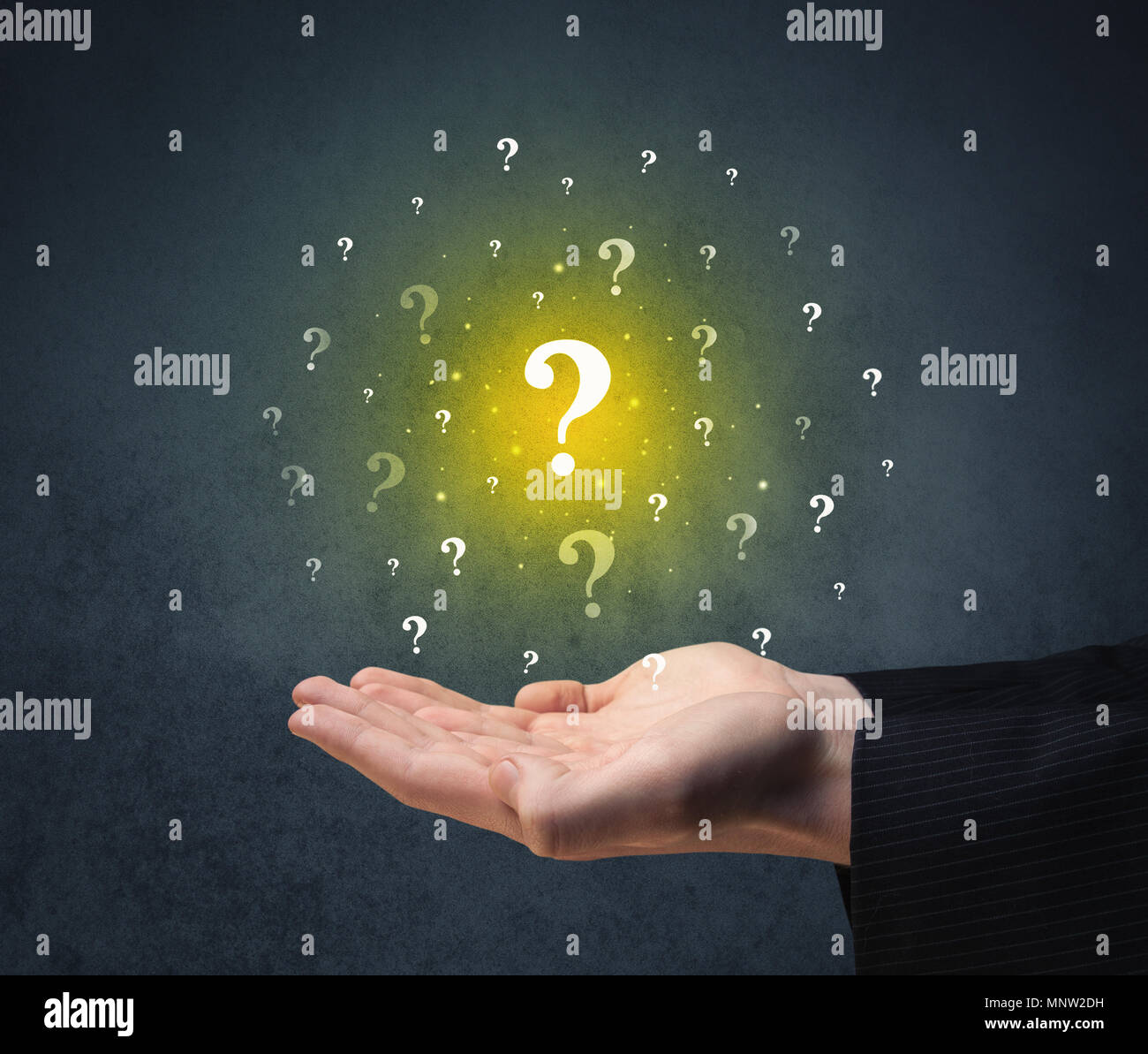 Yellow question marks hovering over young hand Stock Photo - Alamy