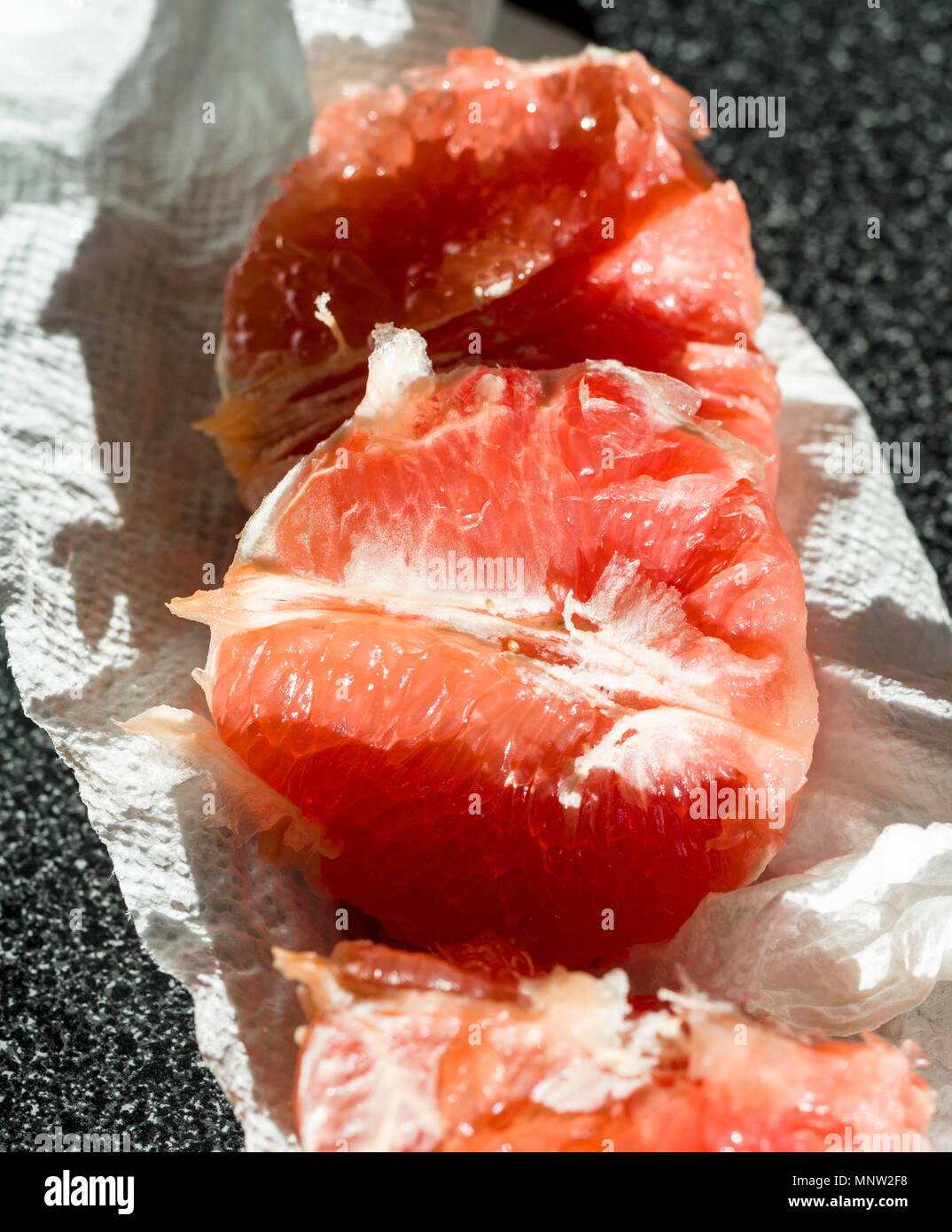 Ruby Red Grapefruit segments: A deep red grapefruit opened and ready to eat shines in the early ...
