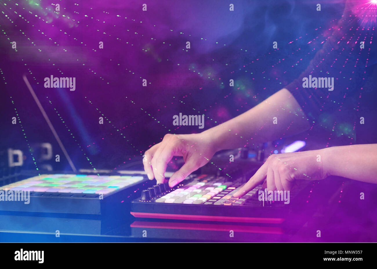 Hand mixing music on dj controller with party club colors around Stock ...