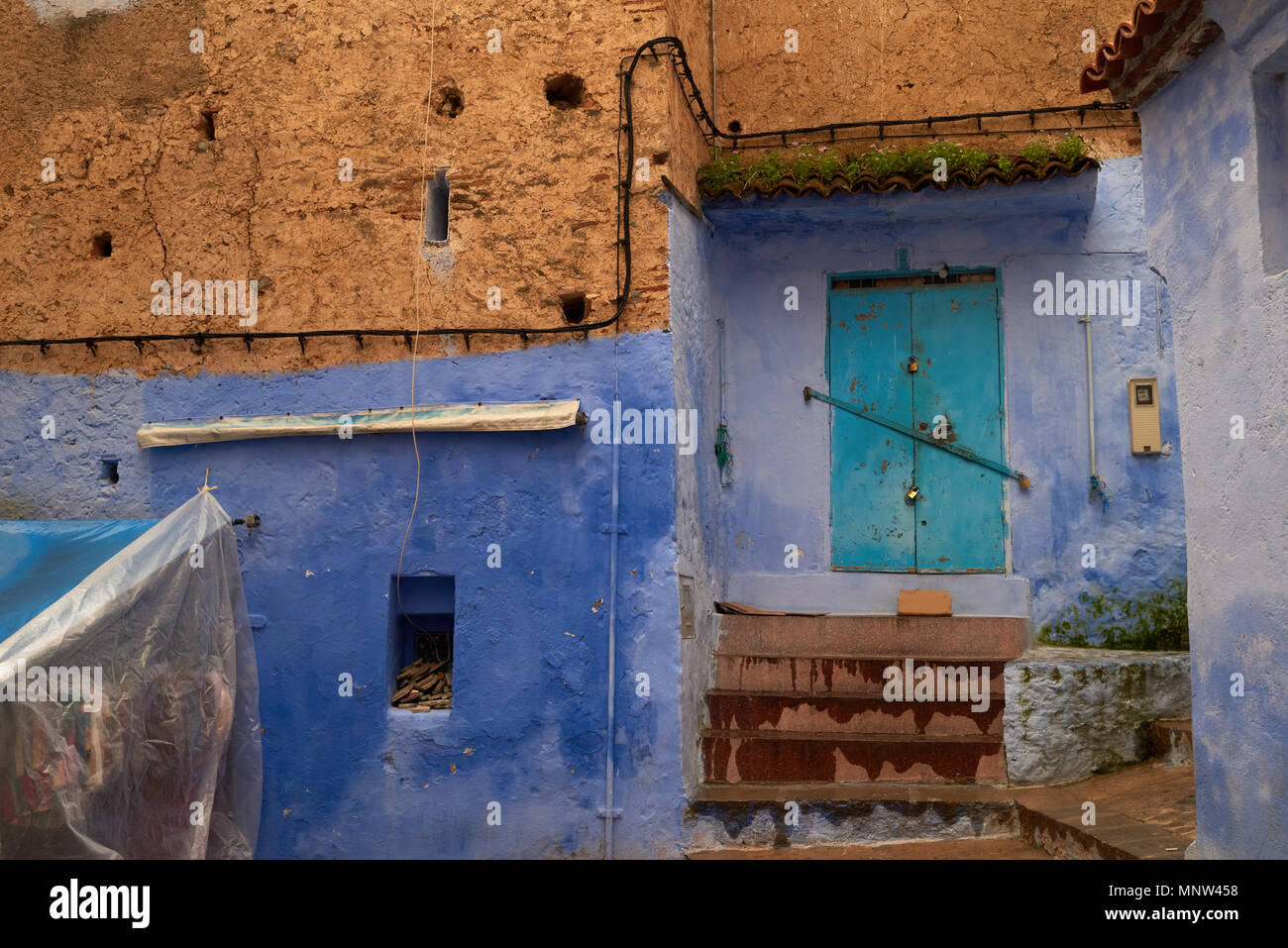 Different colors of blue walls and brown roofs with tiles of medina in ...