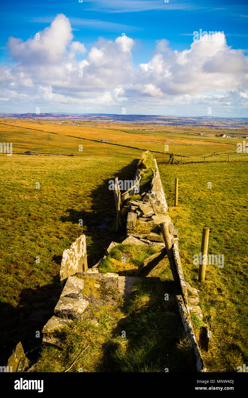 Ancient stone wall in a grassy field at the Cliffs of Moher in County ...