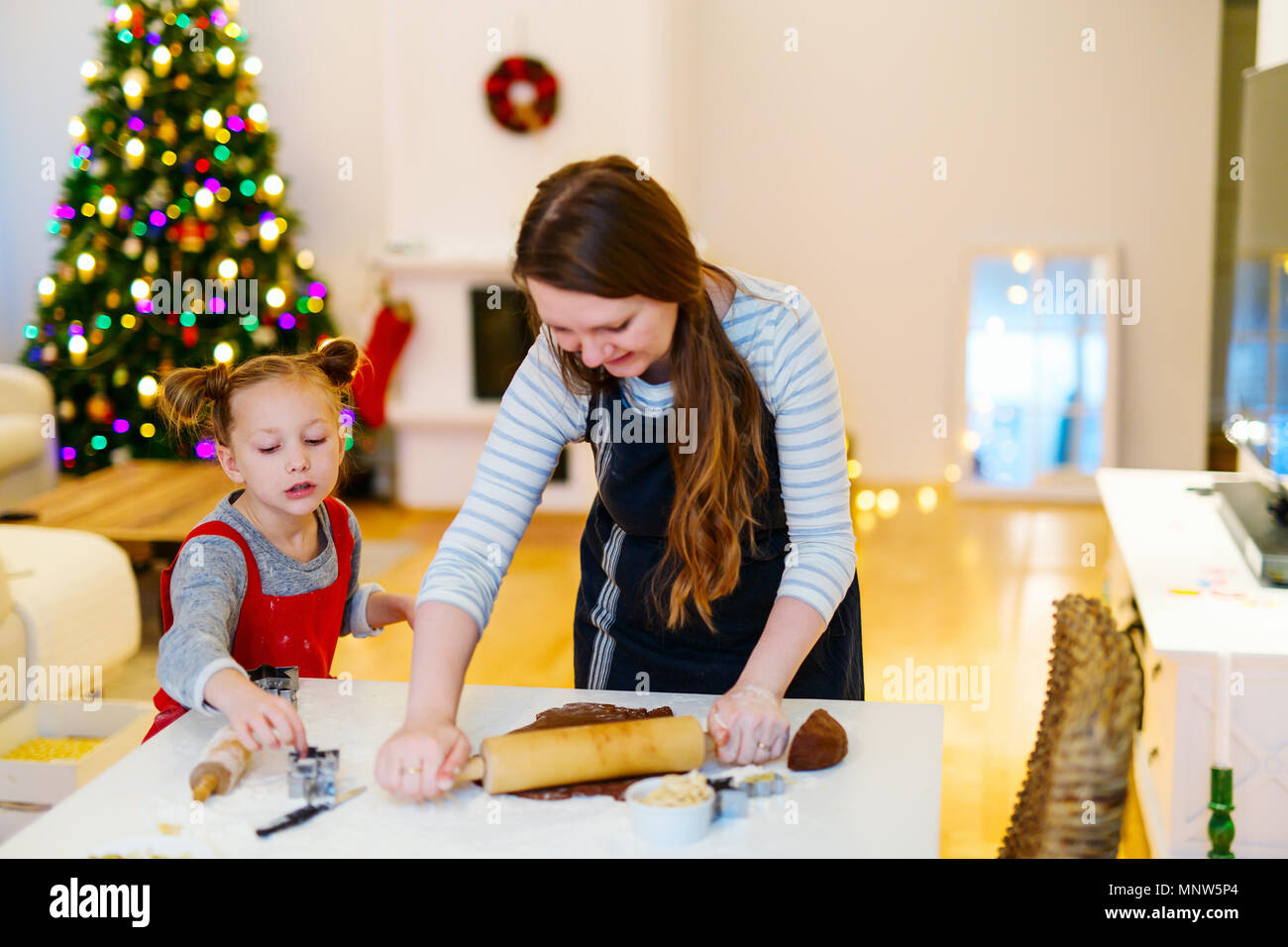 Family of mother and daughter baking cookies at home on Xmas eve ...