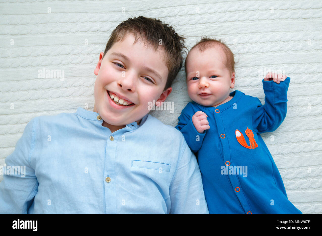 Toddler kid meeting new sibling. Cute boy and new born baby girl relax ...
