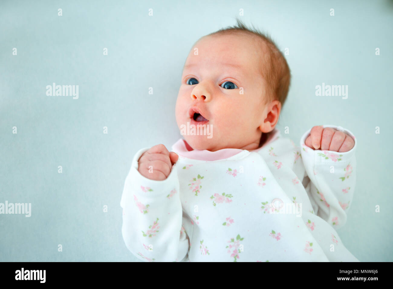 Cute newborn baby girl lying in cradle. Two weeks old infant child on ...