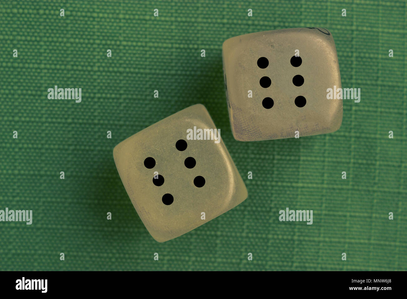 two dice with number six on each on green background Stock Photo - Alamy