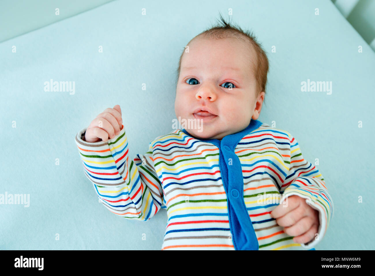 Cute newborn baby girl lying in cradle. Two weeks old infant child on ...