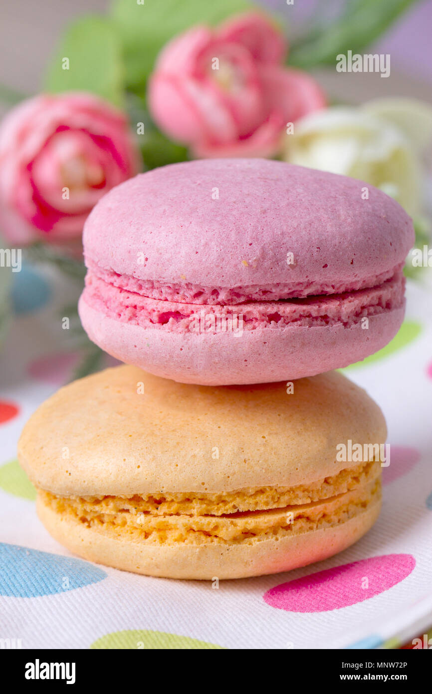 Multicolored macaroon on colorful tablecloth near flowers Stock Photo ...
