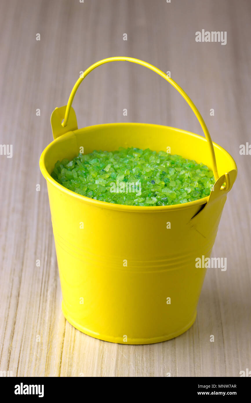 Small yellow bucket with a green sea salt Stock Photo - Alamy