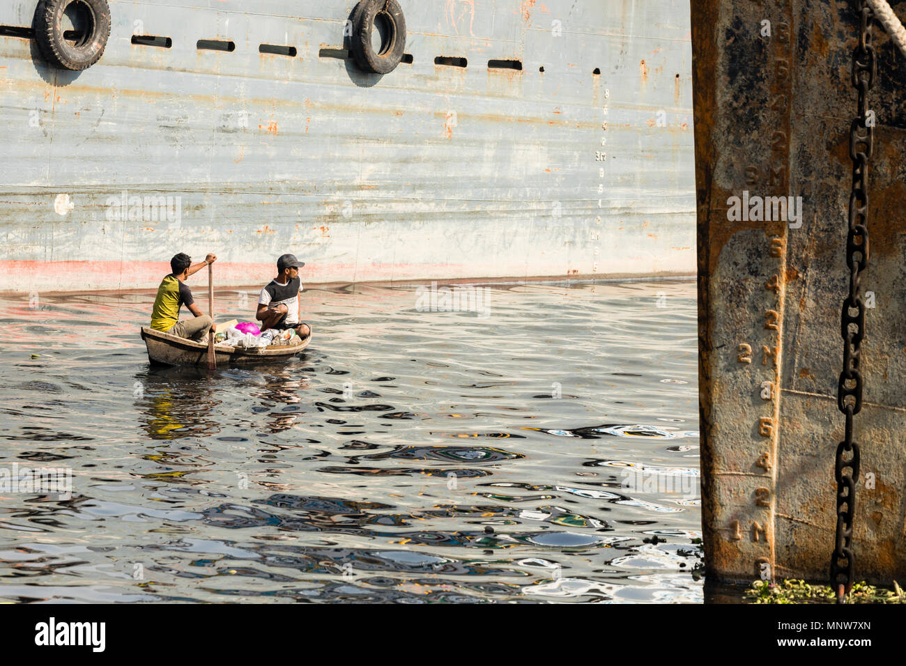 Dhaka, Bangladesh, February 24 2017: Two men ride their wooden boat ...