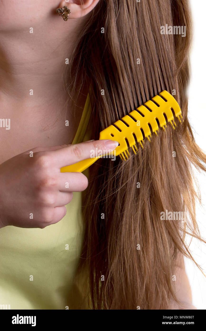 Woman combing her hair yellow, plastic comb Stock Photo - Alamy