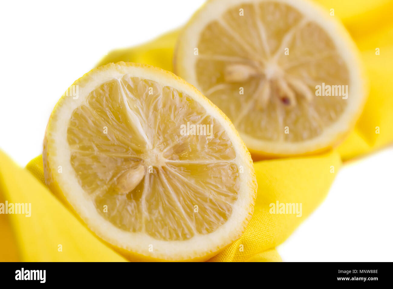 Two halves of lemon on yellow cloth, isolate Stock Photo - Alamy