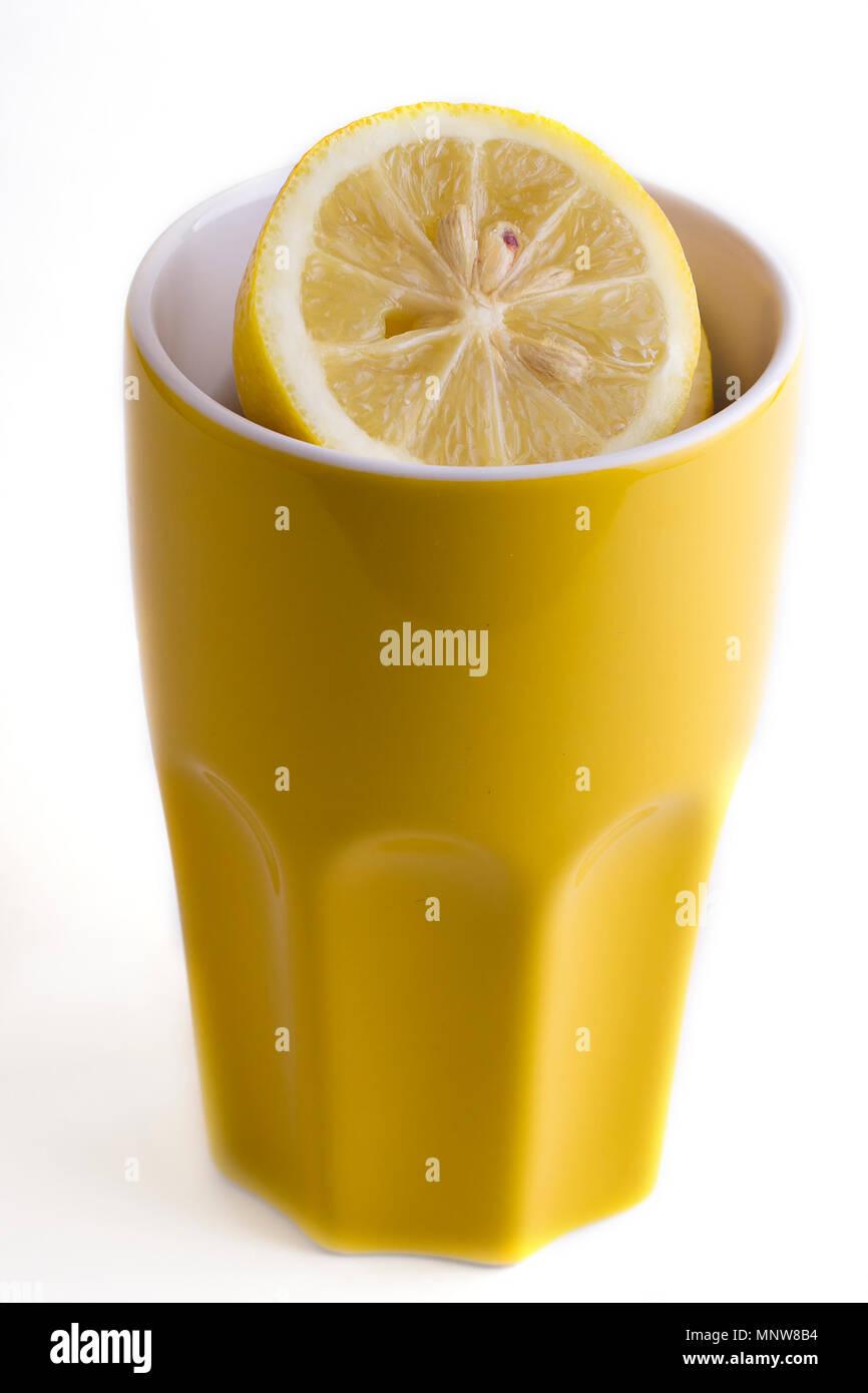Slices of lemon in yellow ceramic glass Stock Photo - Alamy