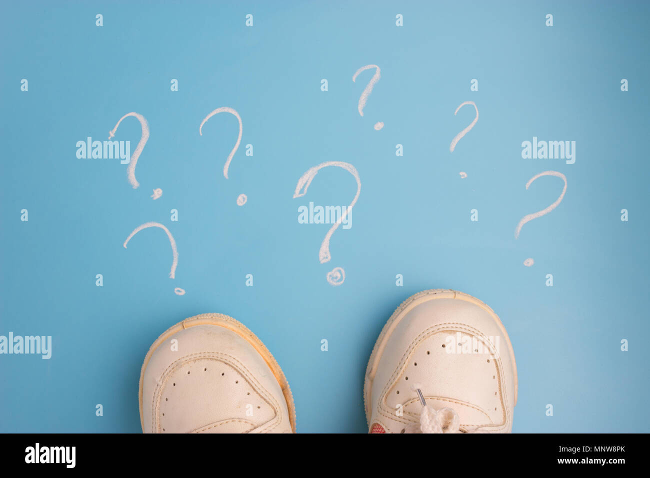 sneaker on blue background Surrounded by question marks Stock Photo - Alamy