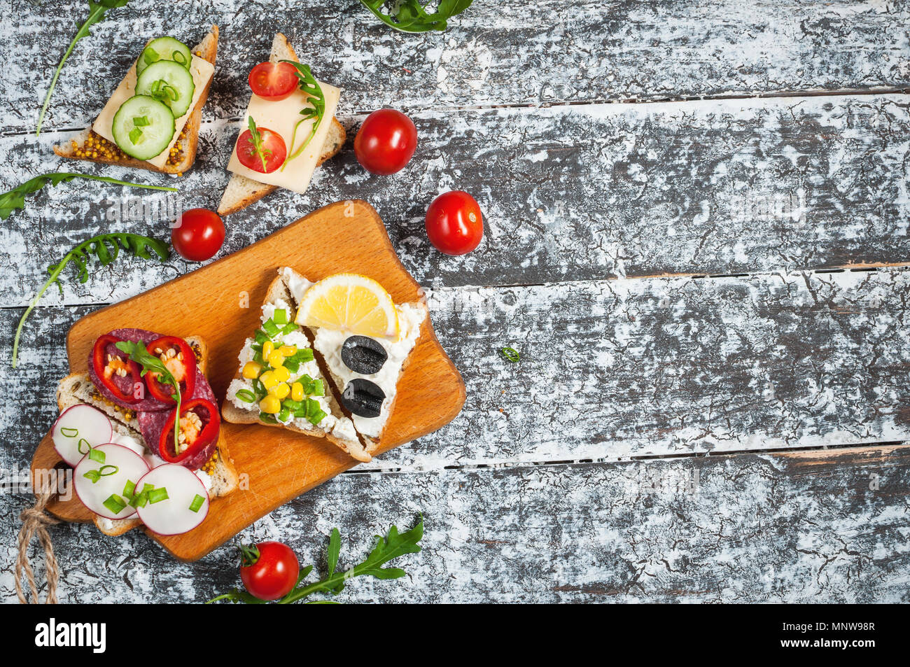 Variety of open sandwiches with different toppings on white backdrop ...