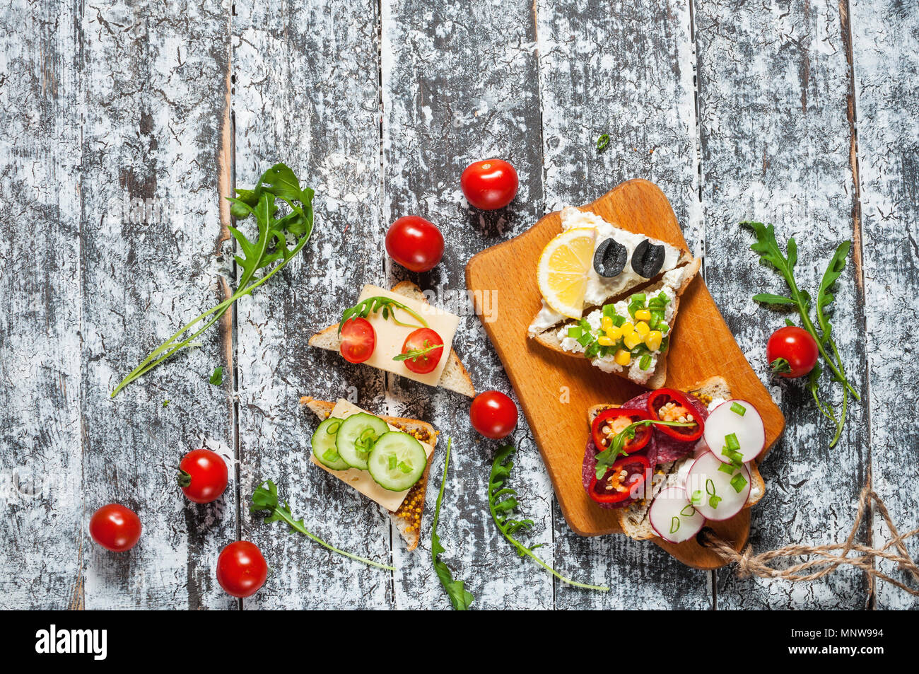 Variety of open sandwiches with different toppings on white backdrop ...