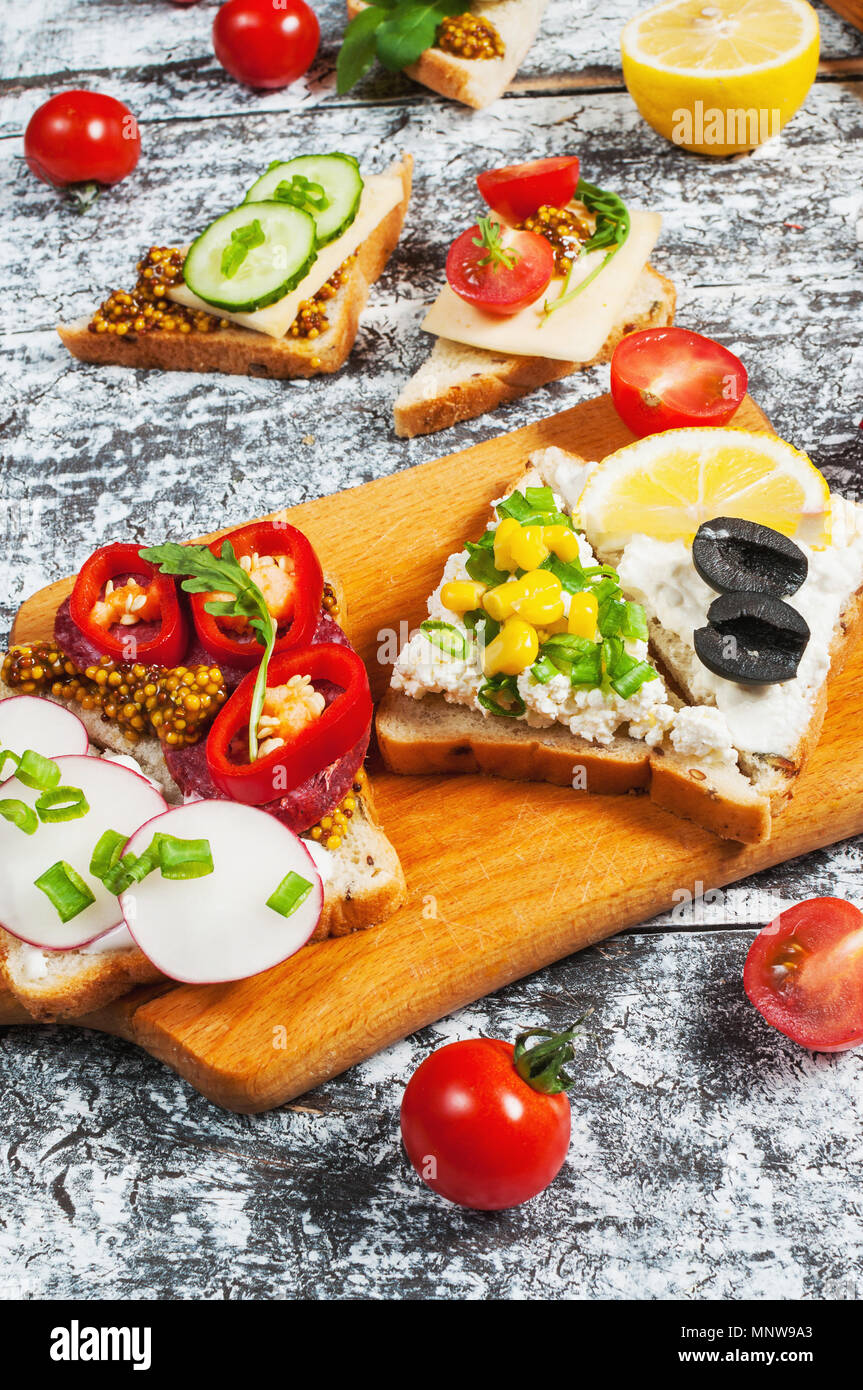 Variety of open sandwiches with different toppings over aged white ...