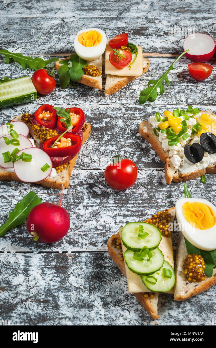 Variety of open sandwiches with different toppings on white backdrop ...