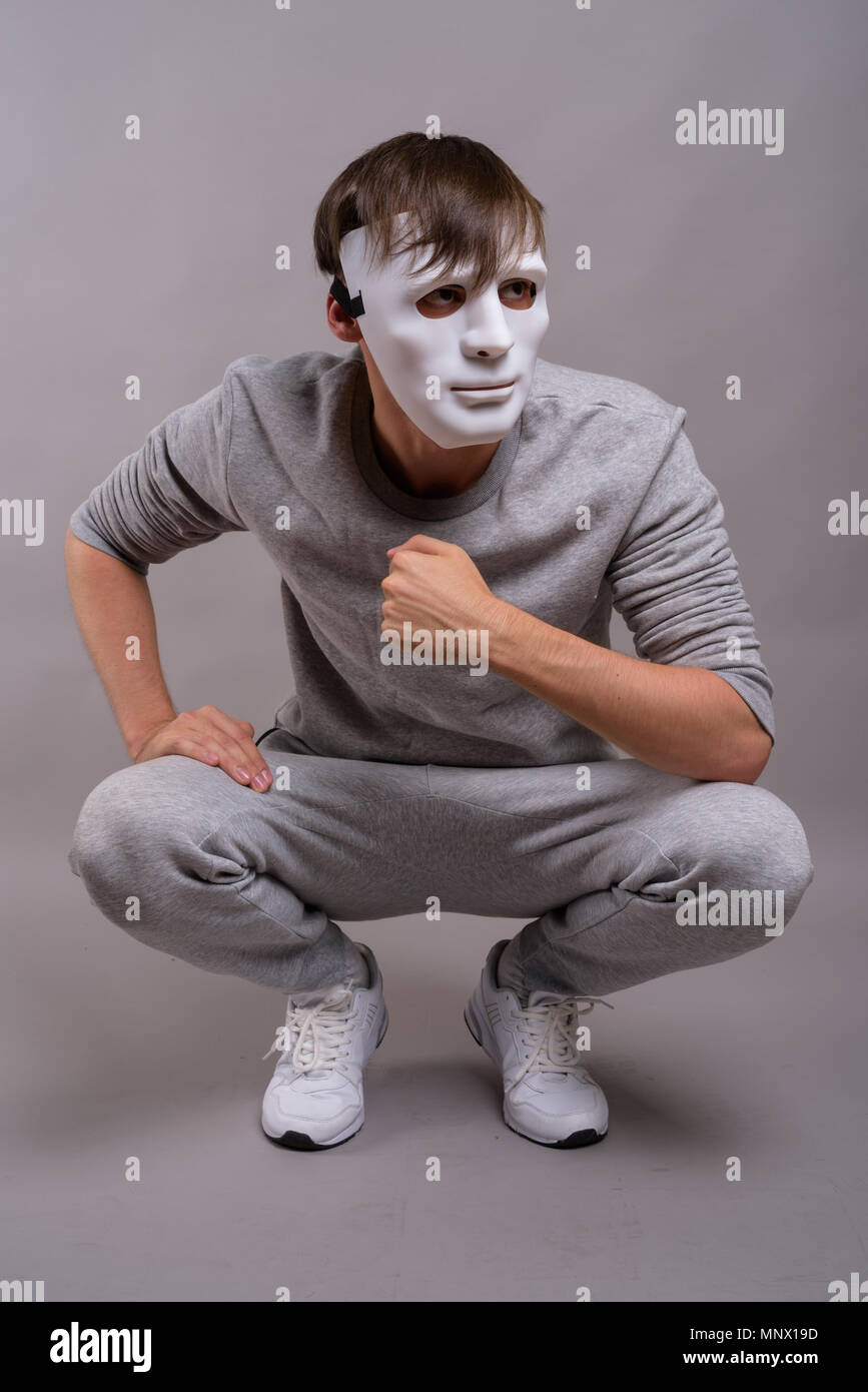Young handsome man wearing white mask against gray background Stock ...