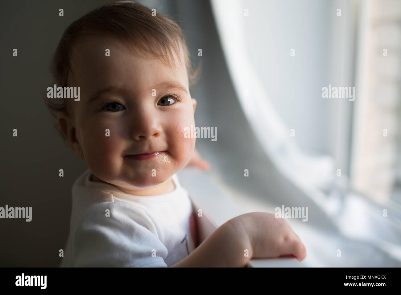 happy and small child near the window Stock Photo - Alamy