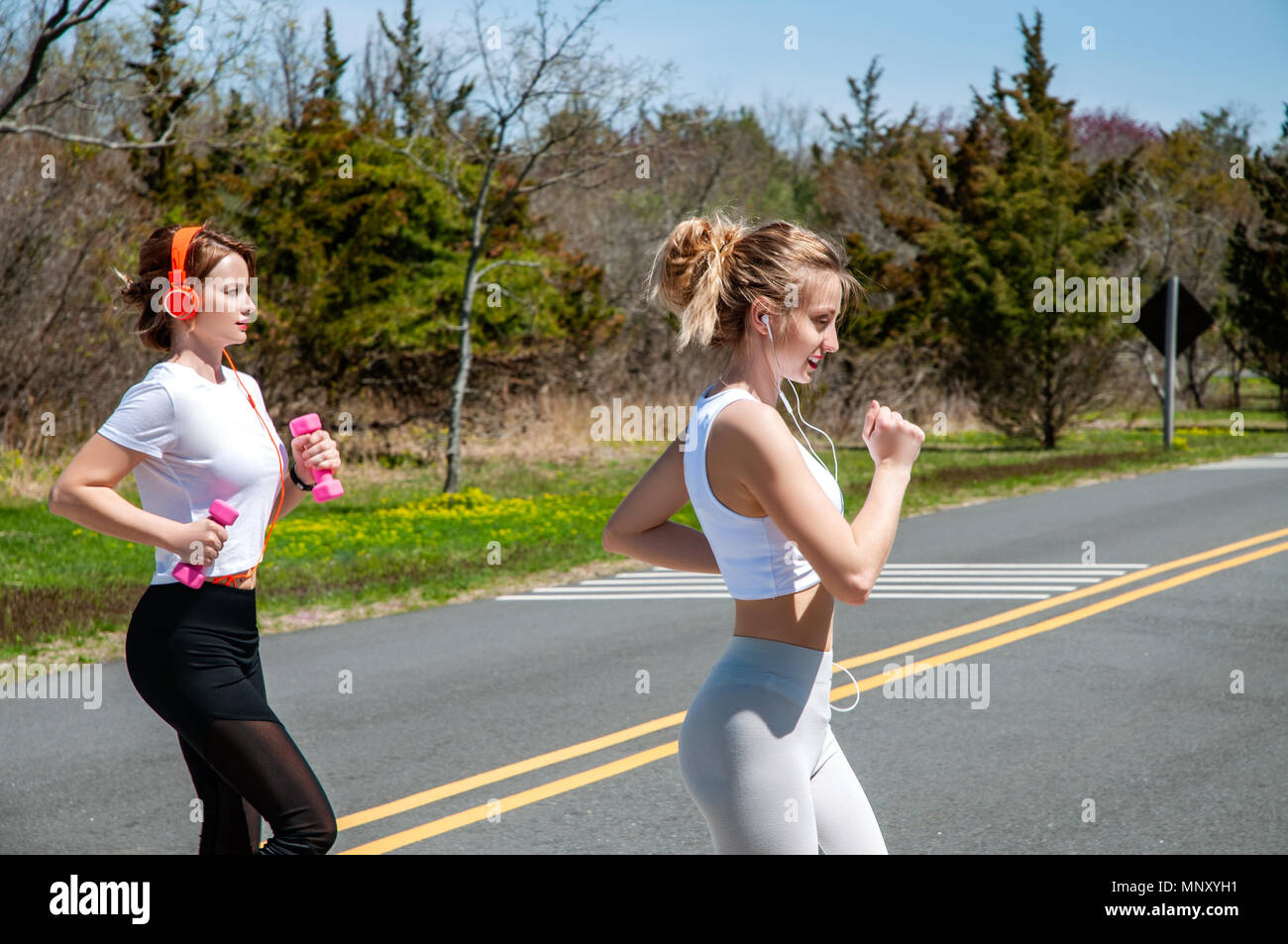 Happy sporty girls running and listening to music. Female fitness ...