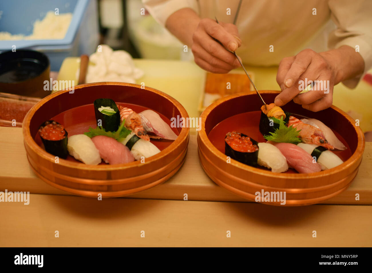 Japanese man preparing fresh sushi in bamboo baskets inside a typical ...