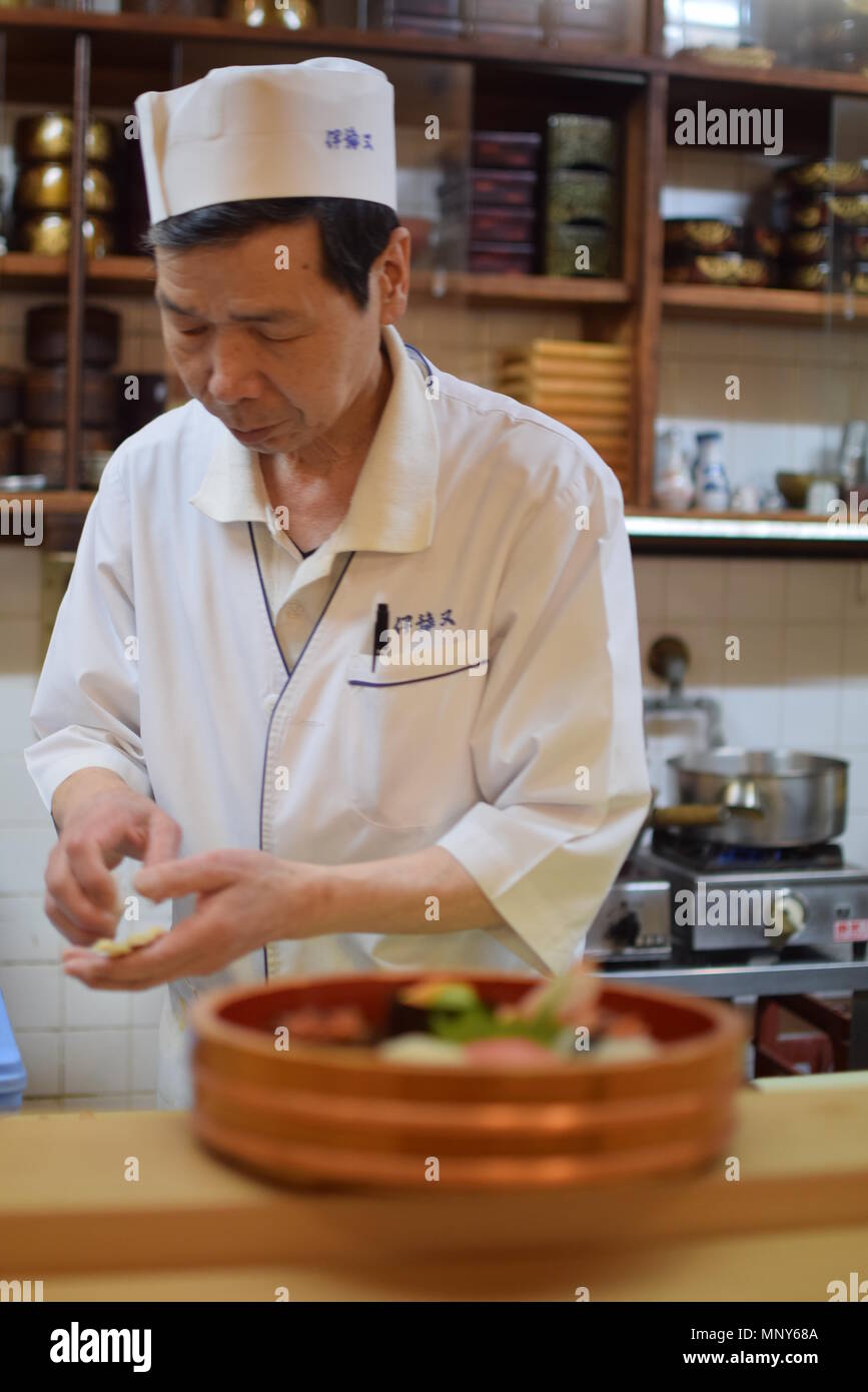 Japanese man preparing fresh sushi in bamboo baskets inside a typical ...
