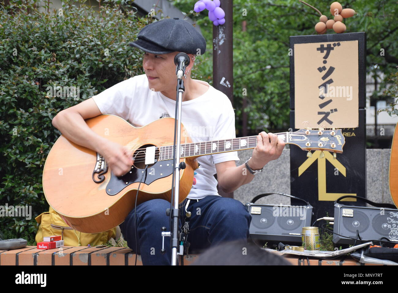 Japanese man with hat playing guitar and sings on the street in Kyoto ...