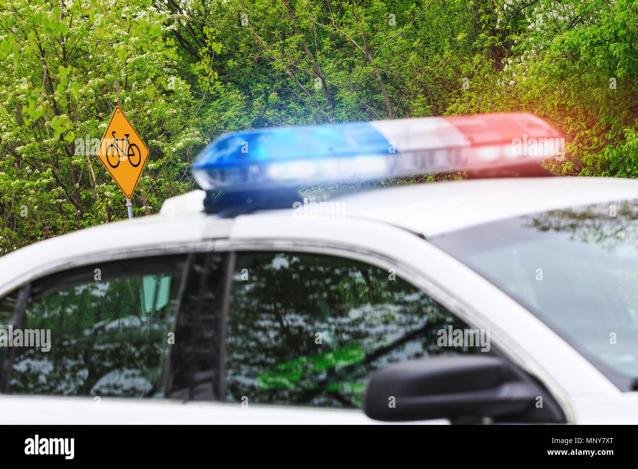 Bicycle or bike road sign with selective focus & police car with ...
