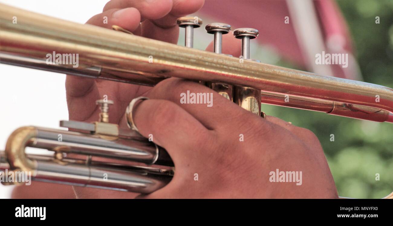 hands on a brass instrument,musicians playing outdoor,close up,image ...