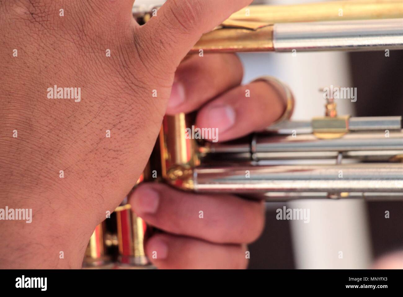 hands on a brass instrument,musicians playing outdoor,close up,image ...