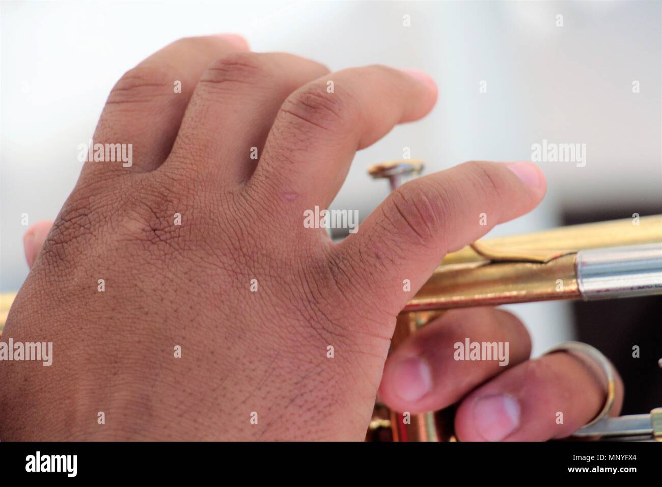 hands on a brass instrument,musicians playing outdoor,close up,image ...