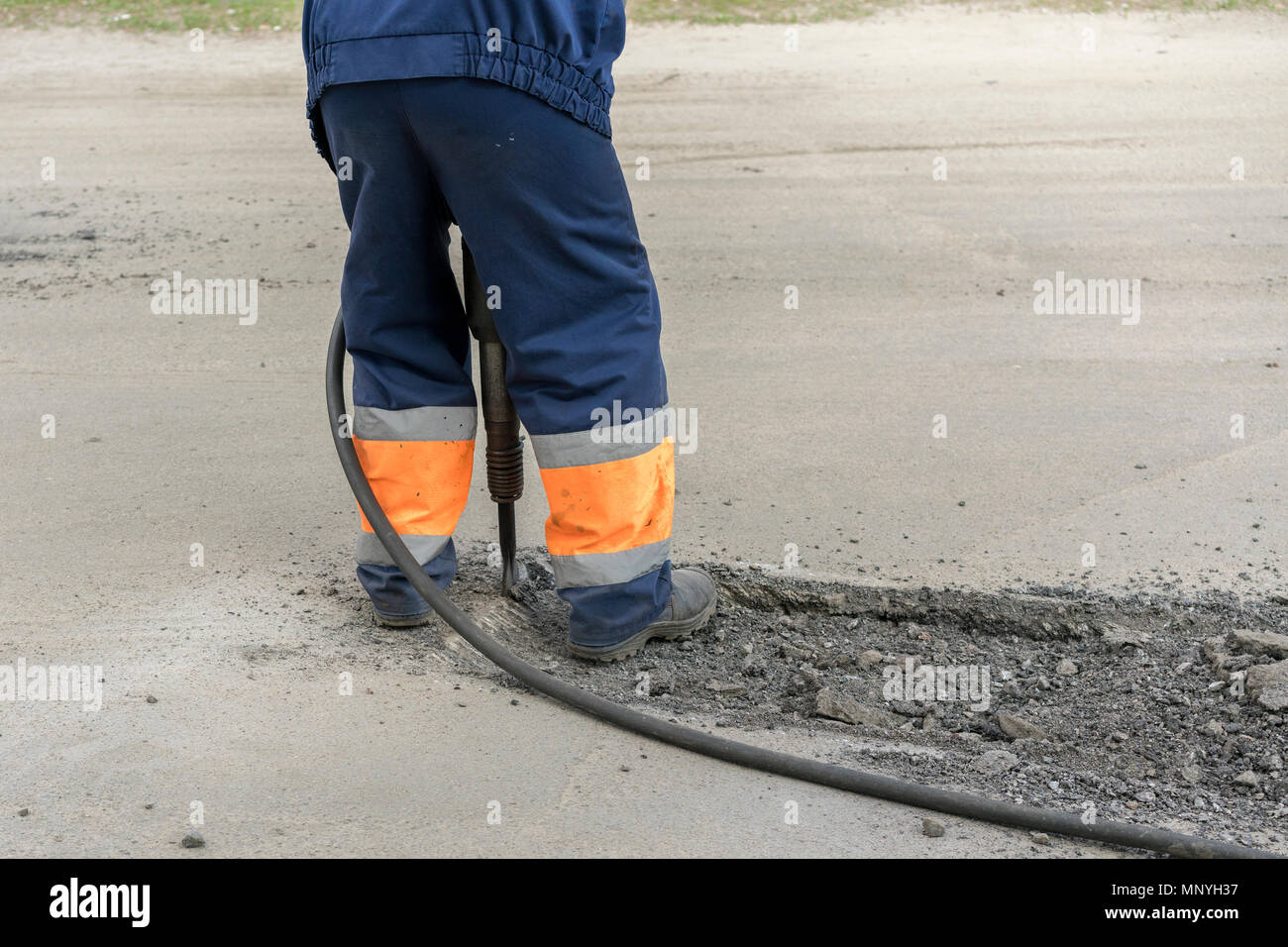 repair of roads. the worker is repairing the road. The man is working ...