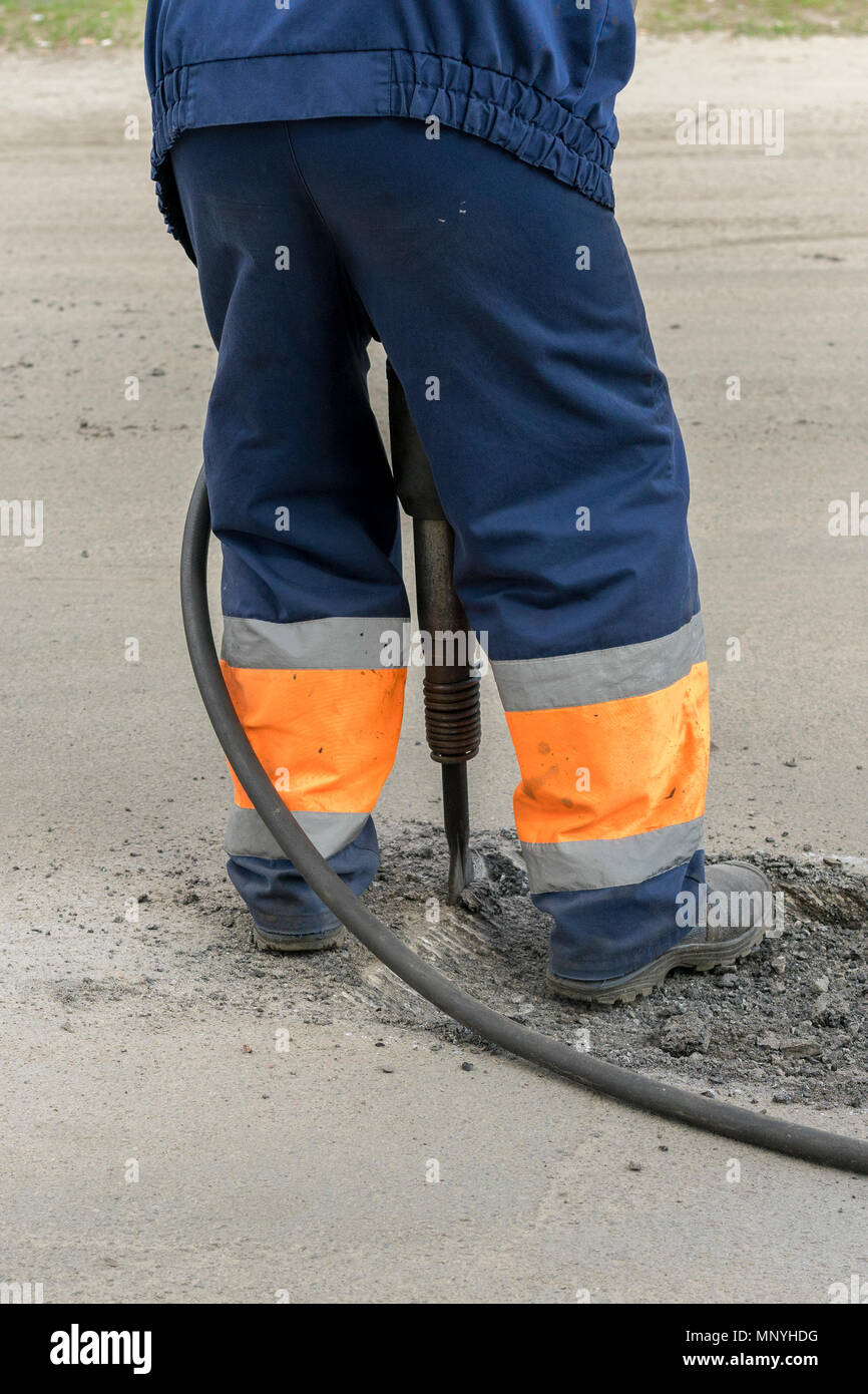 repair of roads. the worker is repairing the road. Road worker close-up ...