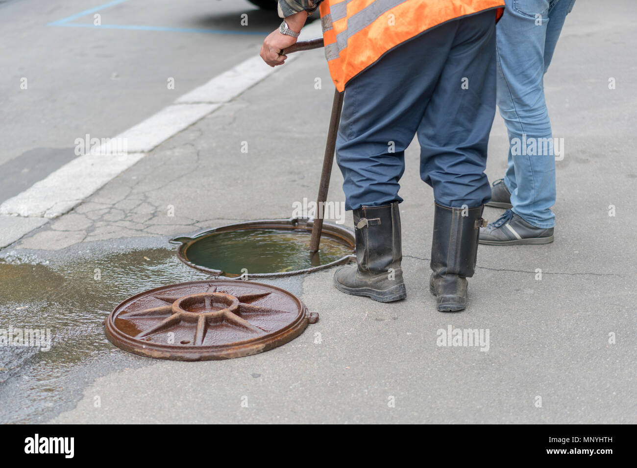 Water supply failure. From the sewer hatch, water flows. Workers near ...