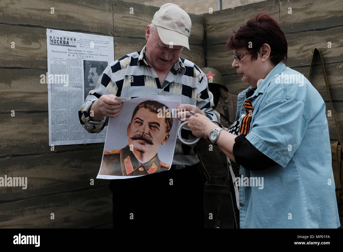 Civilians hold a poster with the photo of Stalin as they set up a ...