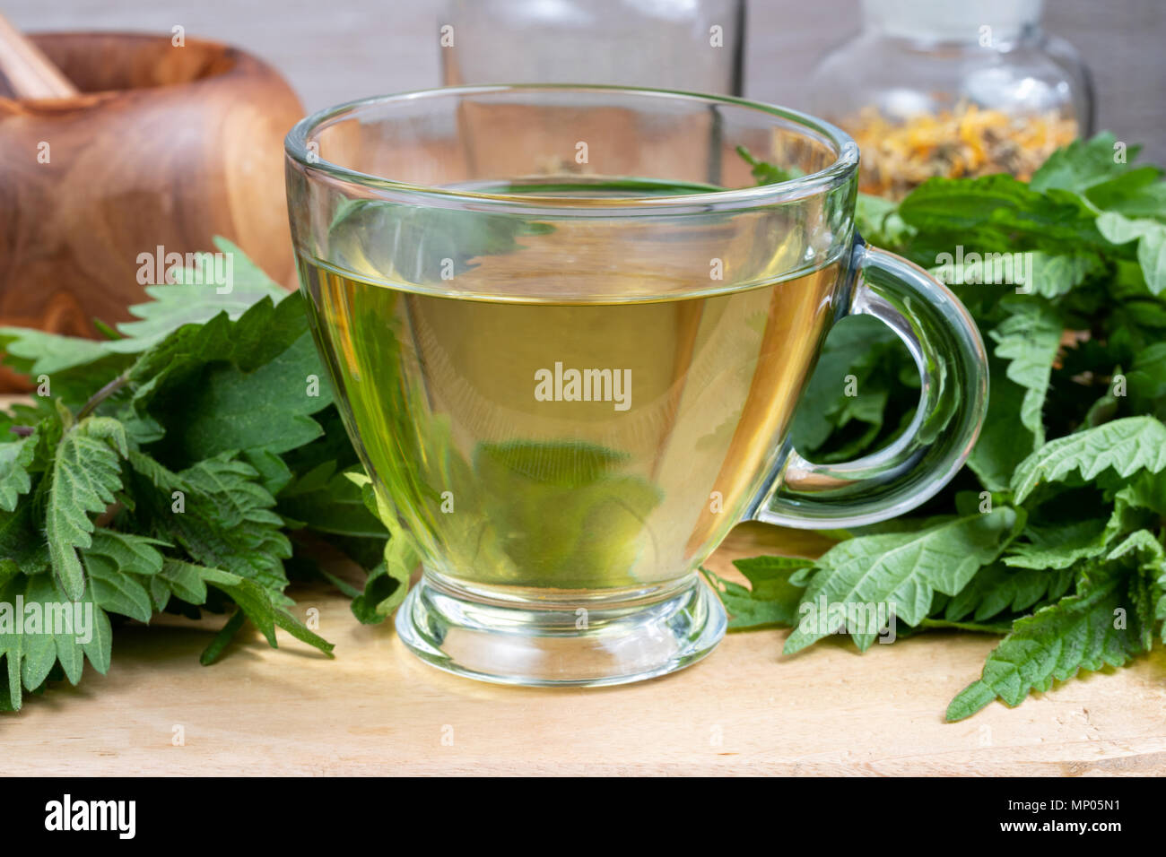 A cup of nettle tea with fresh plant on a table Stock Photo - Alamy