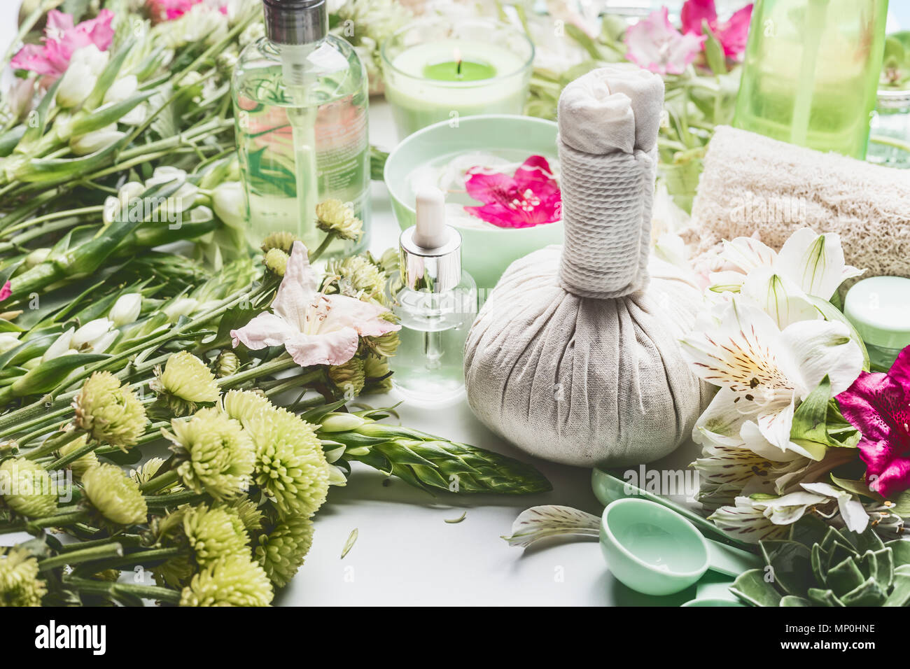 Green herbal spa setting with massage balls, cosmetic products, herbs ...