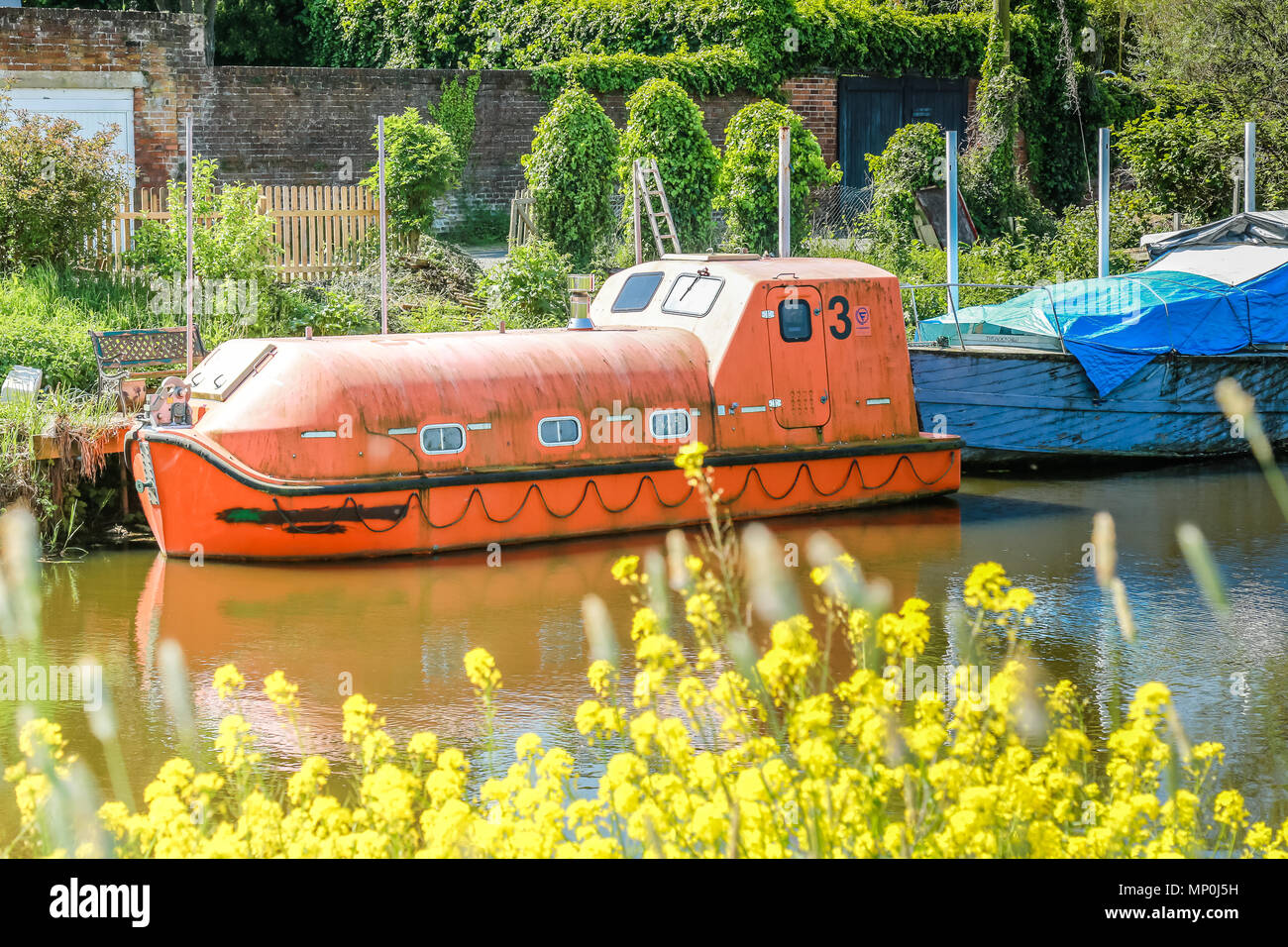 A bright orange rescue boat being used as a houseboat on the River ...