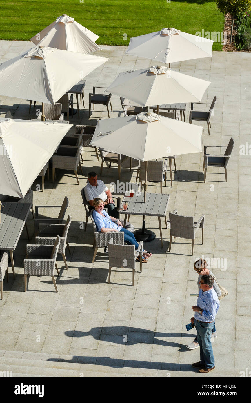 Guests at a luxury hotel sitting on a sunlit terrace Stock Photo - Alamy