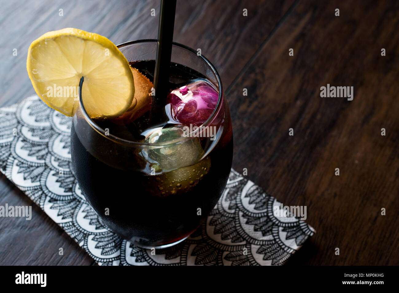 Black lemonade with charcoal, lemon and colorful bubble ice cubes ...