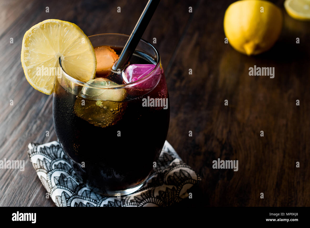 Black lemonade with charcoal, lemon and colorful bubble ice cubes ...