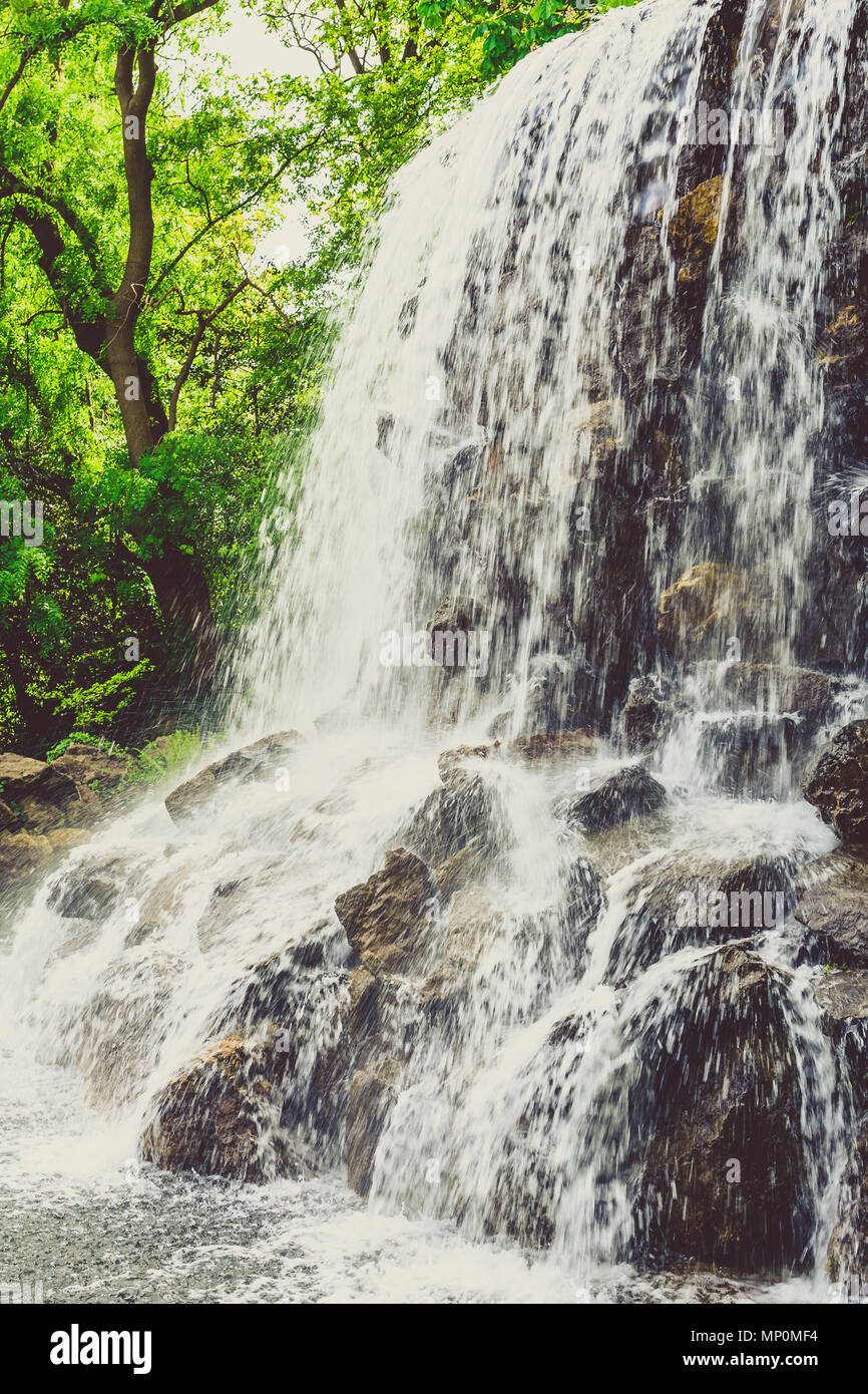 small waterfall in public garden surrounded by greenery Stock Photo - Alamy