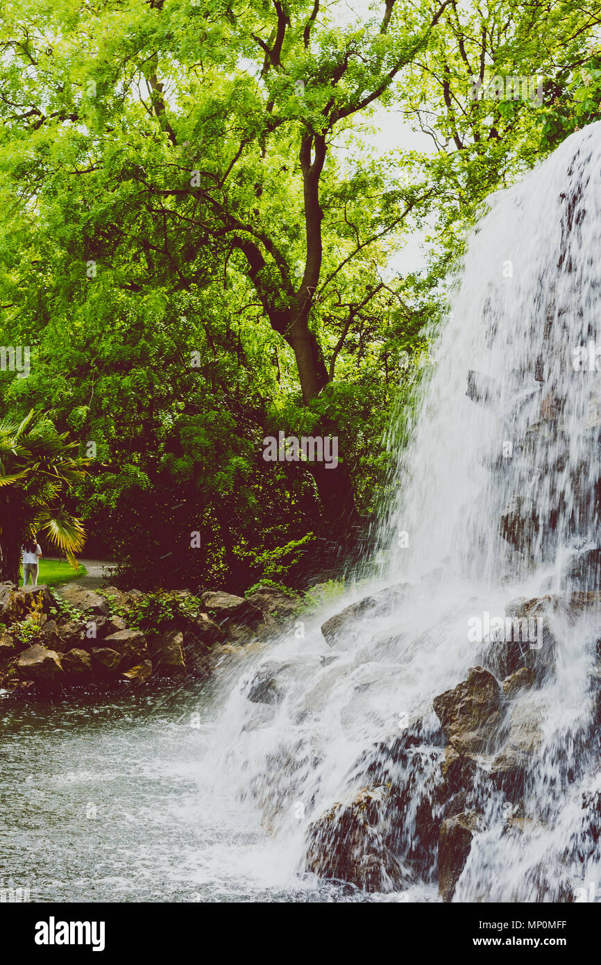 small waterfall in public garden surrounded by greenery Stock Photo - Alamy