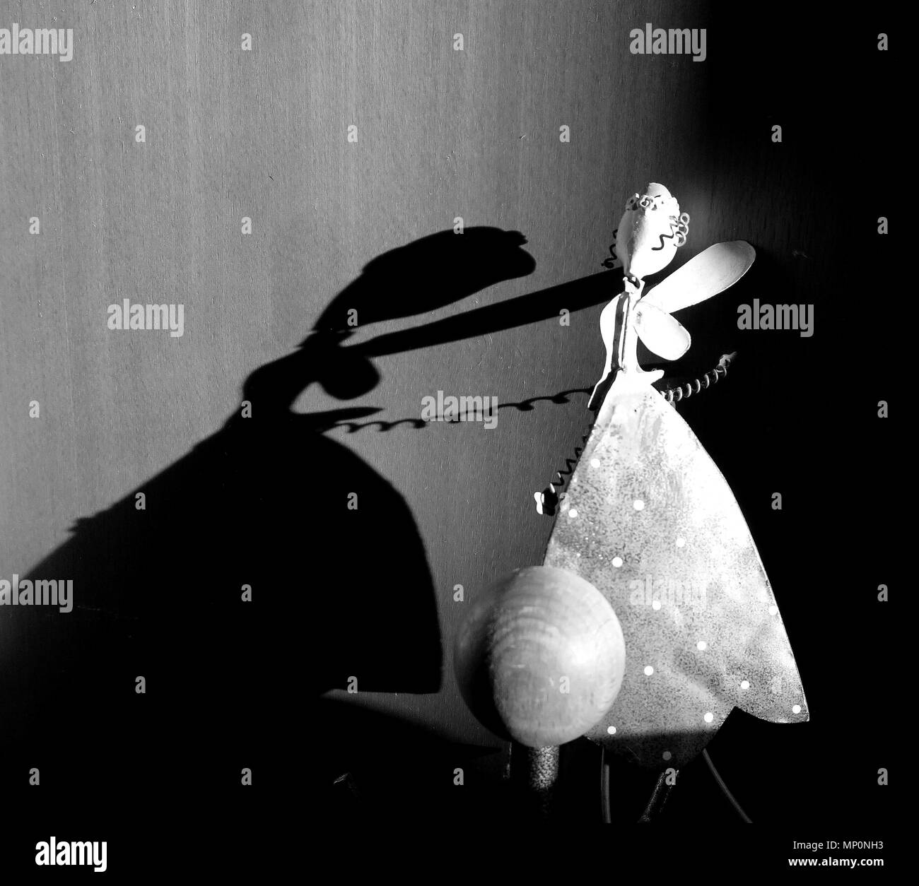 Fairy figure casting its shadow on wooden cupboard. Concept : light and ...